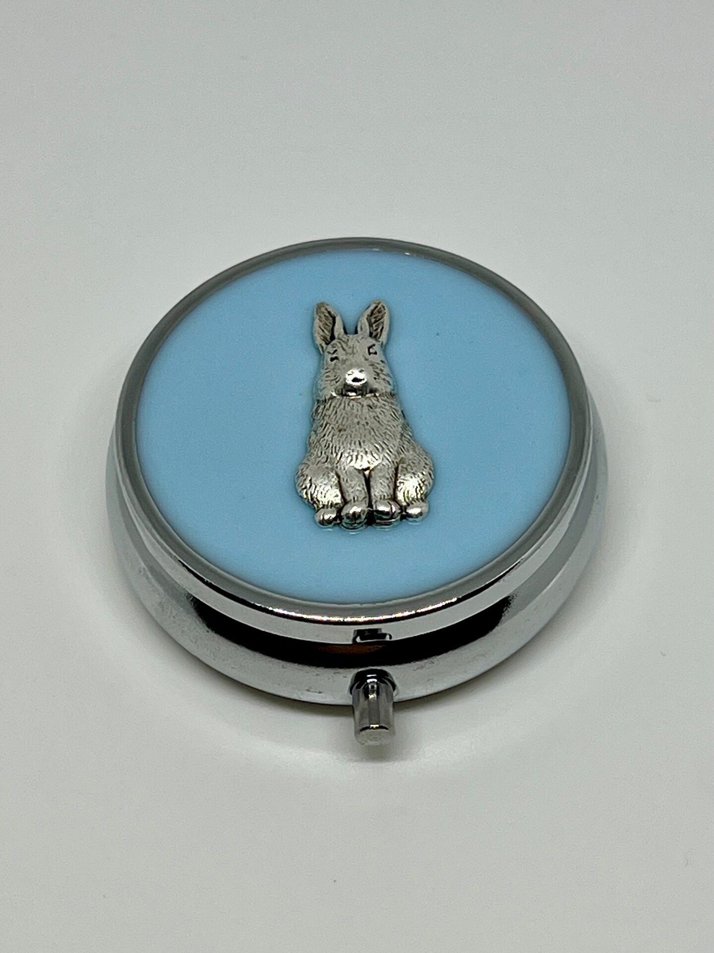 Pill box with silver bunny rabbit set on a blue resin background ...